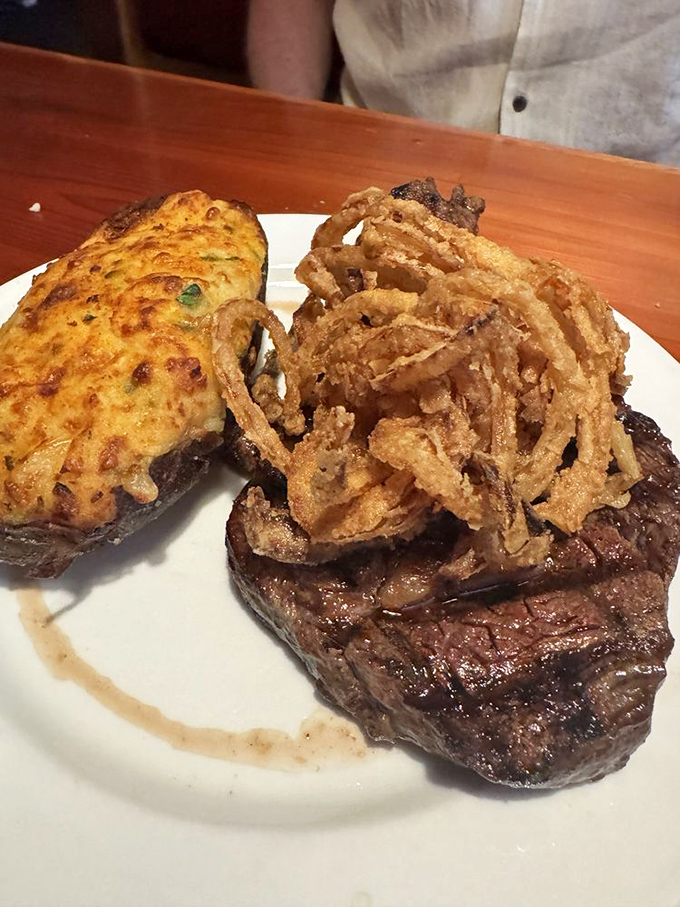A steak topped with crispy onion strings and a stuffed potato&mdash;proof that sometimes the best relationships are the ones that sizzle.