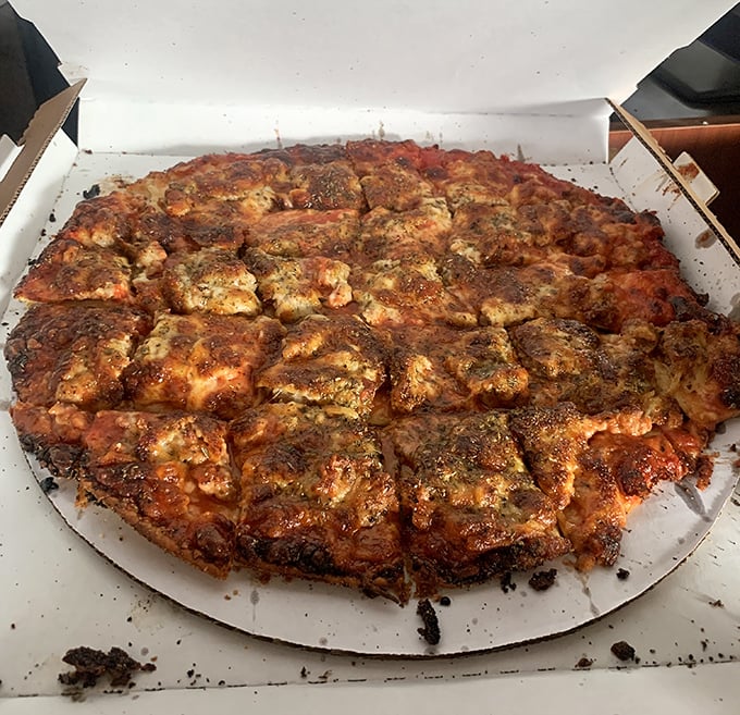 Sausage pizza that laughs at chain restaurant uniformity. Those irregular meat chunks tell you someone's actually making this by hand.