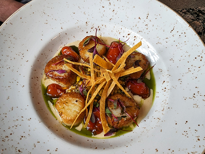 Scallops seared to golden perfection, surrounded by roasted tomatoes and crispy tortilla strips &ndash; ocean meets garden meets art.
