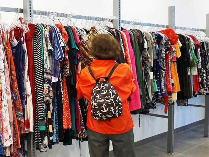 A dedicated shopper browses the technicolor dreamcoat of options, her anchor-patterned backpack suggesting she knows the value of nautical-themed accessories.