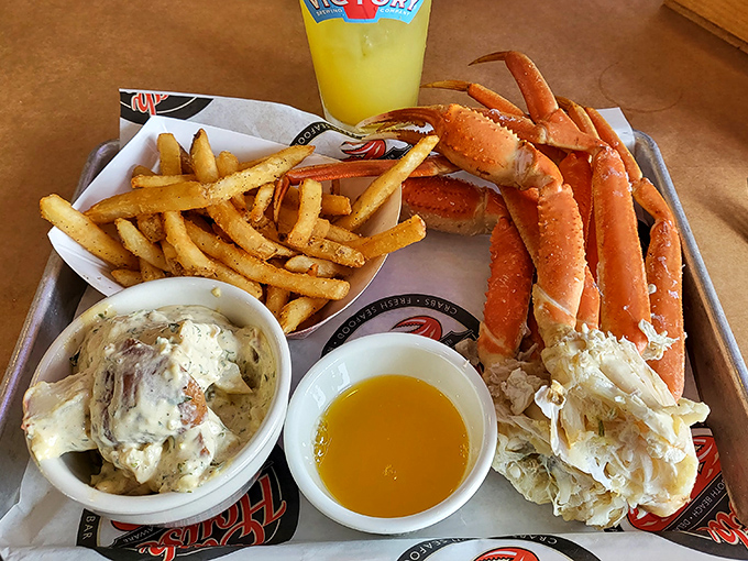 Snow crab legs splayed out like a crustacean sunbather, accompanied by creamy coleslaw and golden fries. The yellow sauce whispers, "Dip me, you know you want to."