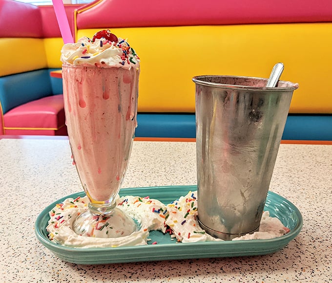 Pink perfection in a glass! This strawberry milkshake wears its whipped cream crown and sprinkles like royalty, while the metal mixing cup offers bonus sips&mdash;like finding an extra $20 in your pocket.