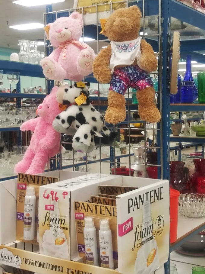 A fuzzy welcoming committee dangles above hair products. These plush companions are just waiting for their forever homes.