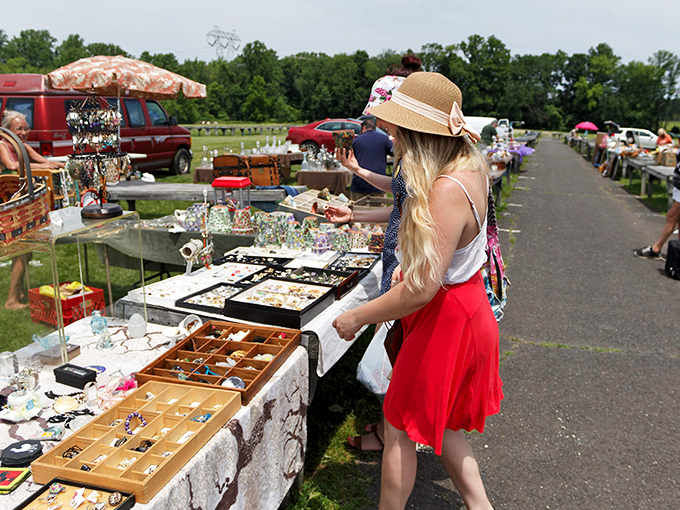 Browsing jewelry under the summer sun, this shopper demonstrates the art of the flea market safari. The red skirt says "I mean business!"