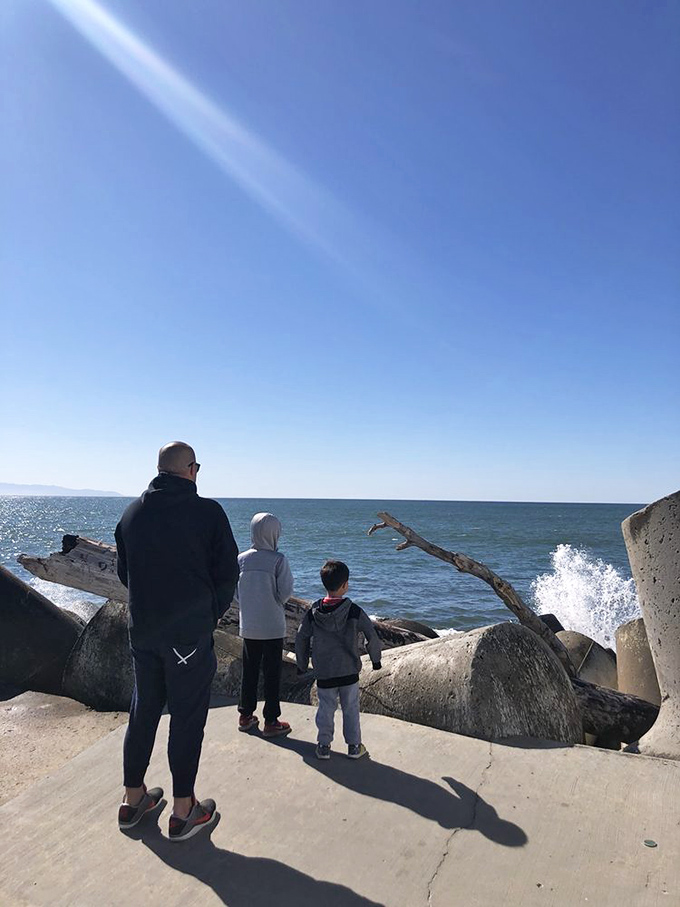 Families find their perfect vantage point along the jetty, where the drama of crashing waves meets the safety of solid ground. 