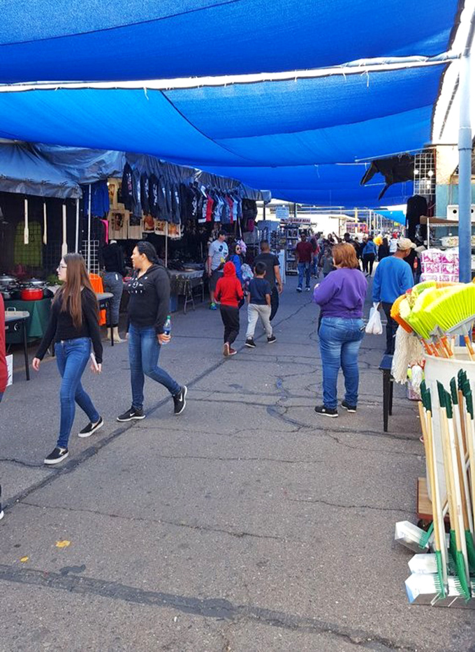 Blue tarps create shopping boulevards where treasure hunters stroll with the focused determination of seasoned prospectors.