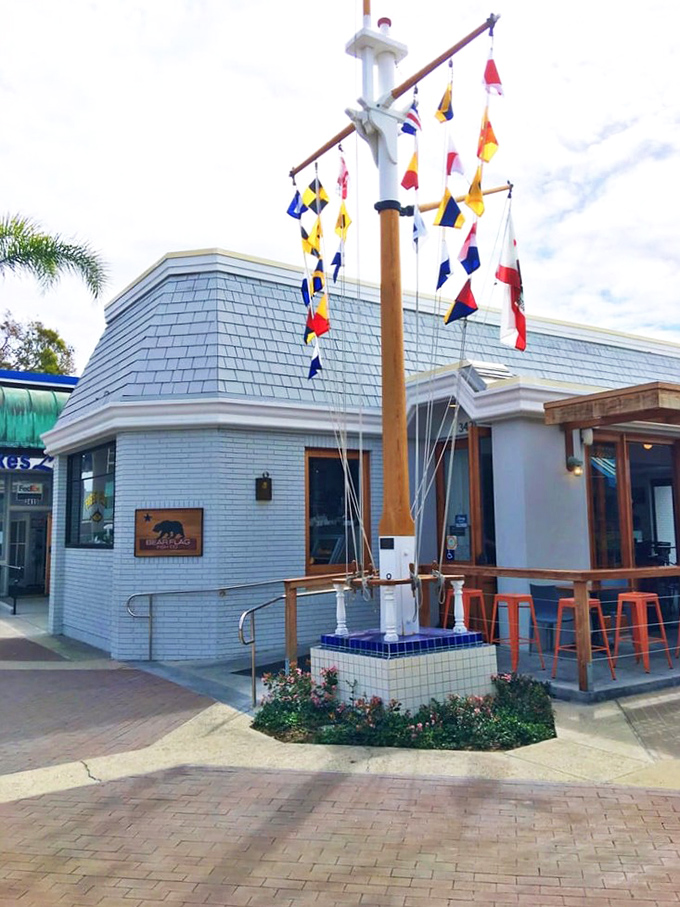 Colorful flags wave like maritime signals, beckoning seafood lovers to discover Newport Beach's hidden culinary treasure.