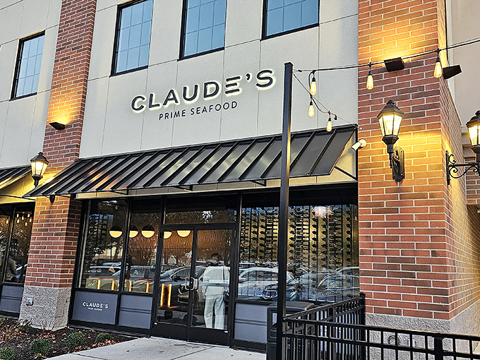 Claude's elegant brick exterior glows at twilight &ndash; sophisticated seafood awaits behind those warm, welcoming lights.