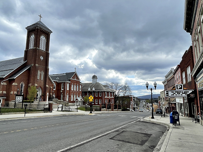 Frostburg&rsquo;s Main Street blends historic charm with small-town warmth, where brick facades and a towering church steeple set the scene against the mountain backdrop.