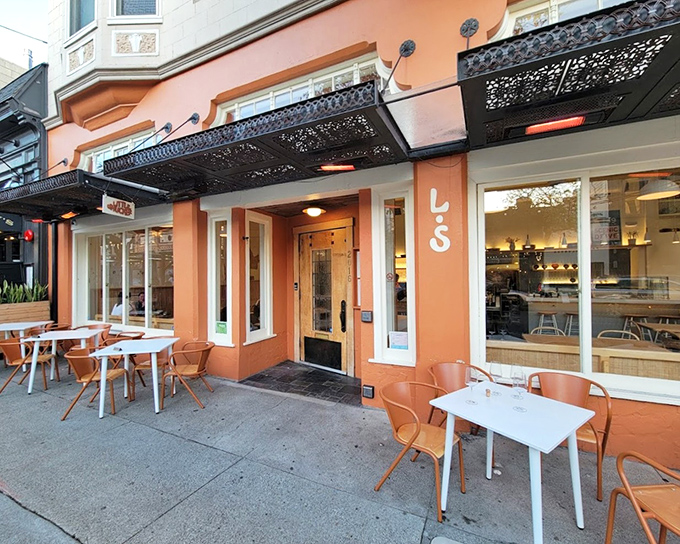 Little Shucker's orange facade glows like a beacon for oyster lovers seeking their next perfect bite.