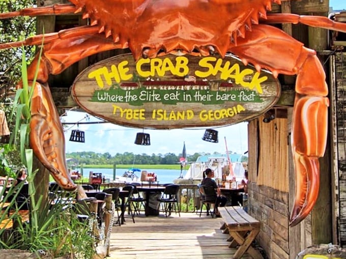 The Crab Shack's giant crustacean guardian announces: "Where the elite eat in their bare feet" &ndash; coastal dining perfection!