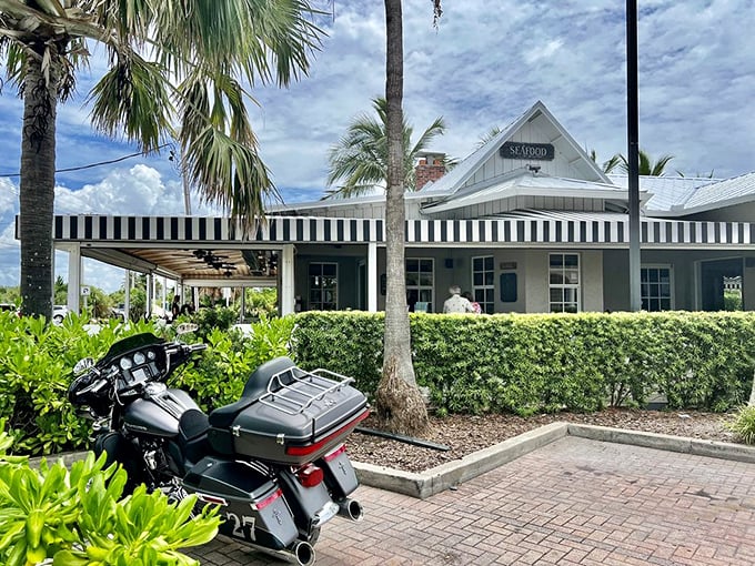 Classic coastal charm! The Waterfront's crisp black-and-white awnings and lush landscaping create the perfect backdrop for motorcycle enthusiasts and seafood lovers alike.