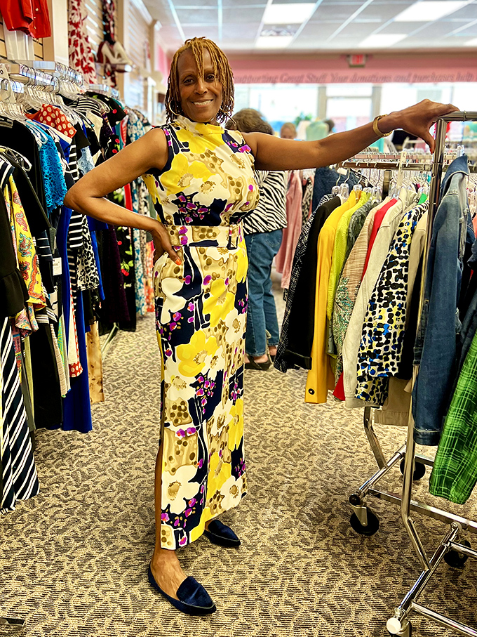 A happy shopper models a vibrant floral dress, proving that thrift store fashion can be both stylish and affordable.