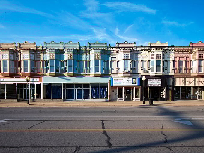 The vibrant storefronts of downtown Iola create a rainbow effect against the blue Kansas sky&mdash;affordable small-town living with unexpected visual charm.