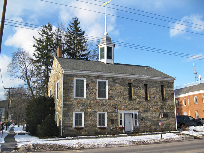 Milford&rsquo;s historic stone building stands strong through the seasons, its weathered walls echoing stories of the past.