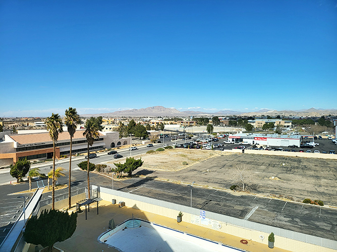 Victorville stretches toward distant mountains like a sunbather reaching for lotion&mdash;palm trees and empty pools hint at desert life's rhythms.