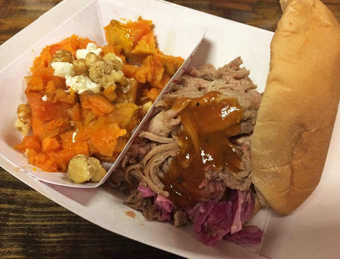A study in contrasts: tender pulled pork, vibrant slaw, and sweet potatoes topped with goat cheese create a plate that's both rustic and refined.