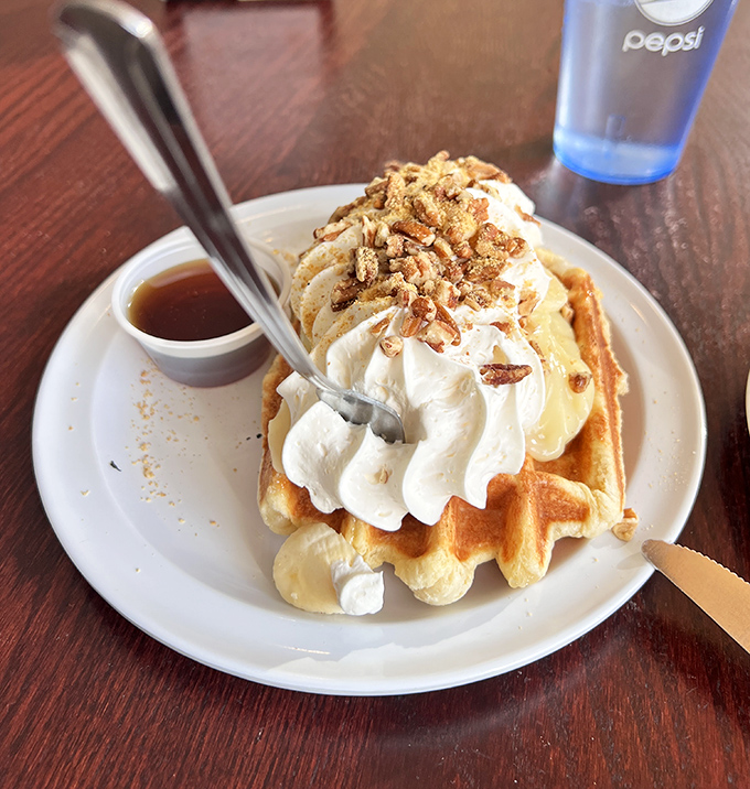 Behold the waffle that launched a thousand road trips! Whipped cream mountain, crunchy topping, and that little cup of syrup standing by.