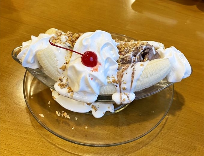 The banana split arrives like a cloud formation&mdash;peaks of whipped cream, valleys of ice cream, and that signature cherry summit. 