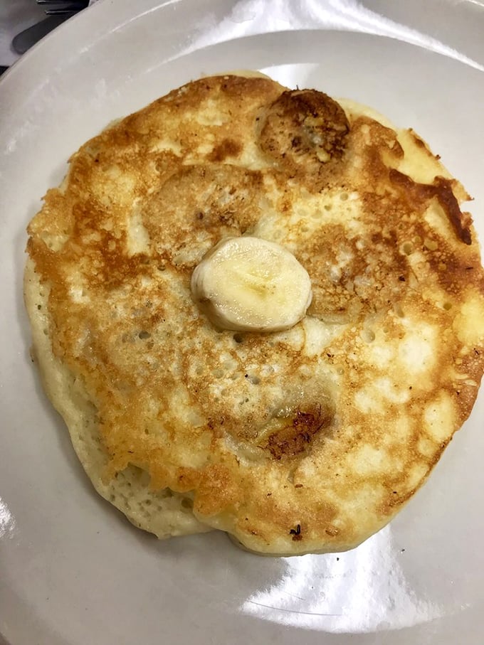 Golden pancake perfection with a pat of butter slowly melting into its warm embrace. Maple syrup application is your sacred responsibility. 