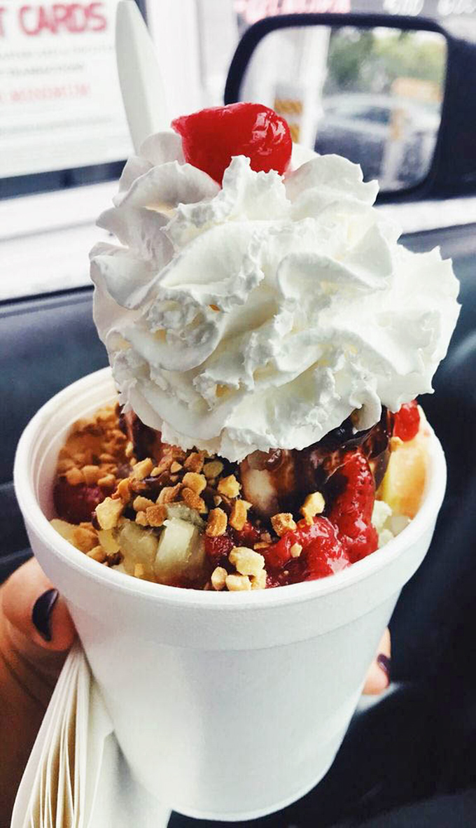 A sundae that requires both strategy and commitment. The whipped cream mountain sits atop a valley of fruit, nuts, and pure joy.