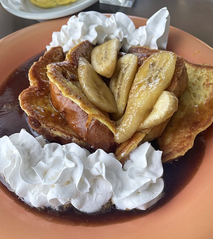 French toast that crossed paths with bananas Foster and never looked back. The whipped cream islands are just showing off at this point.