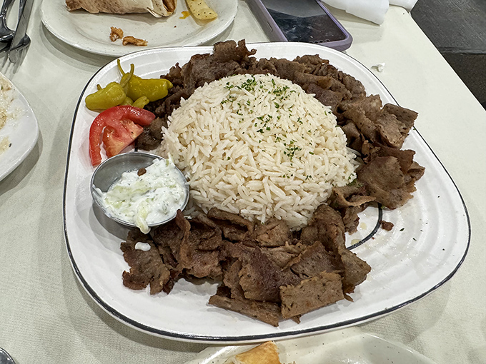 Beef shawarma that's had a proper education – graduating with honors atop a fluffy rice pillow with yogurt sauce as its valedictorian speech.