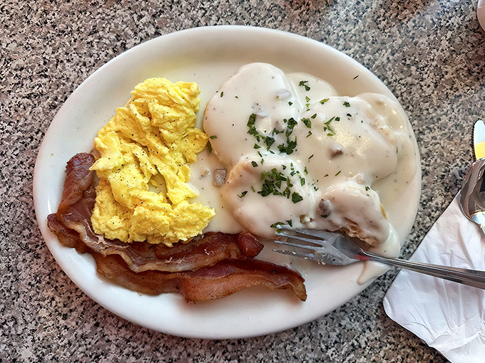 Biscuits swimming in country gravy alongside golden scrambled eggs and bacon. The breakfast equivalent of a warm hug from your favorite grandma.