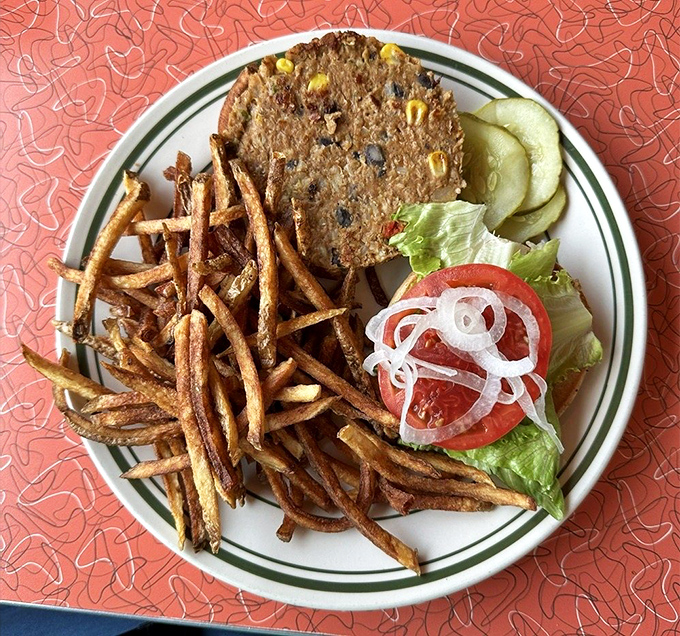 The black bean burger stands proud among its meat counterparts, flanked by crispy fries that could convert even the most dedicated carnivore.