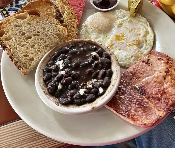 A breakfast plate that hits all the right notes: perfectly fried eggs, artisanal toast, black beans, and ham that would make any morning person out of a night owl.
