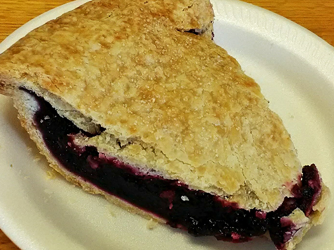 The berry-stained lattice crust whispers sweet promises, while the filling holds the essence of summer in every purple-hued bite.