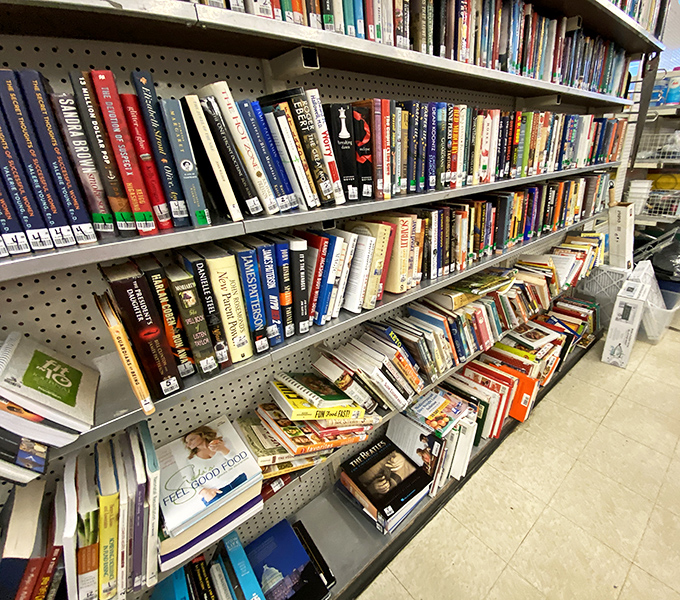 Literary treasures stacked spine-out, where bestsellers and forgotten gems share shelf space in democratic fashion, all priced for impulse buying.