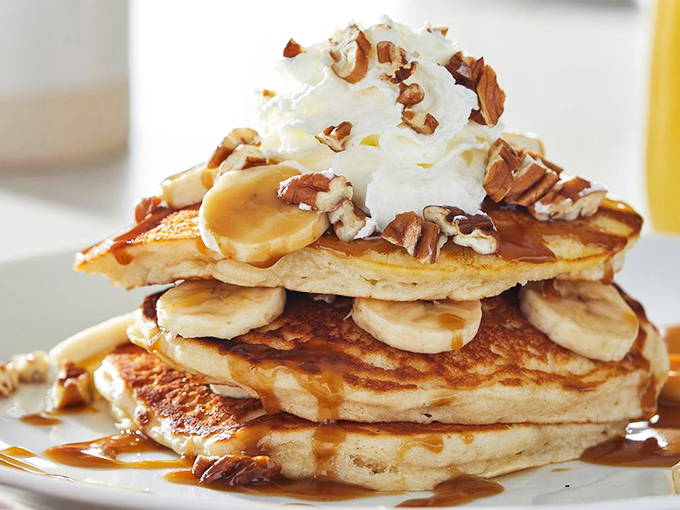 Pancake architecture at its finest&mdash;layers of fluffy goodness topped with bananas, pecans, and enough whipped cream to make Monday disappear.