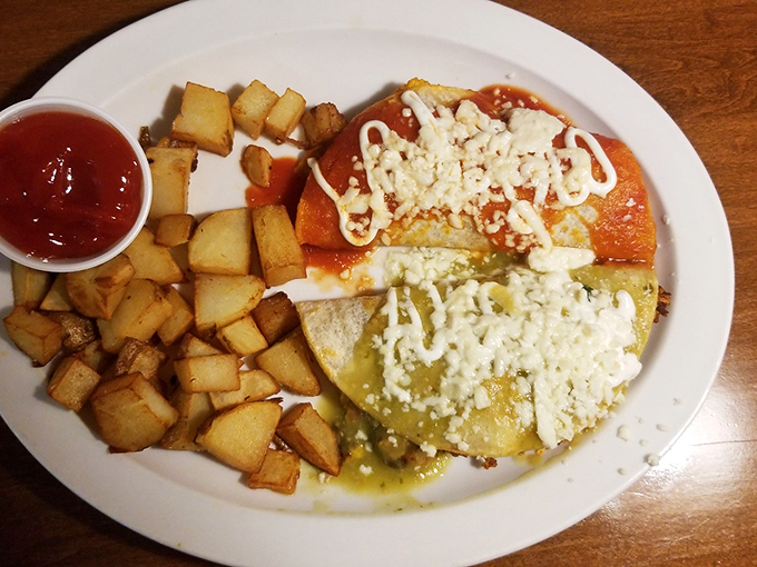 Breakfast enchiladas that bridge cultures deliciously. Red and green sauces create a Christmas-colored fiesta on a plate, with home fries playing perfect sidekick.