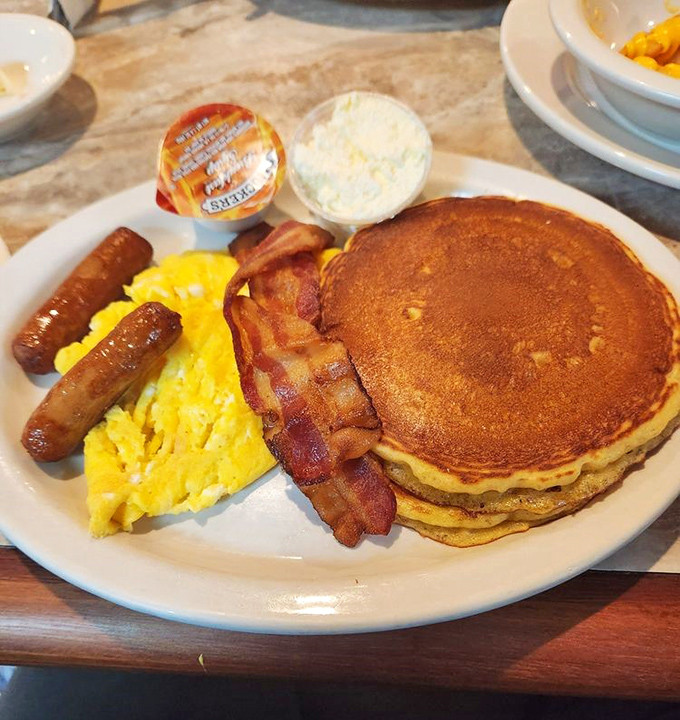 The holy trinity of breakfast perfection: golden pancakes, perfectly scrambled eggs, and bacon that's achieved that magical crisp-yet-chewy state.