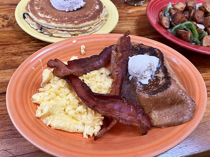 Breakfast nirvana achieved: scrambled eggs fluffier than clouds, bacon crisped to perfection, and French toast that deserves its own fan club.