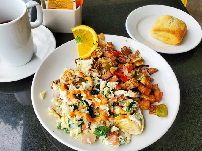 Breakfast nirvana: a colorful medley of eggs, home fries, and veggies that makes waking up worthwhile, with a biscuit standing guard.