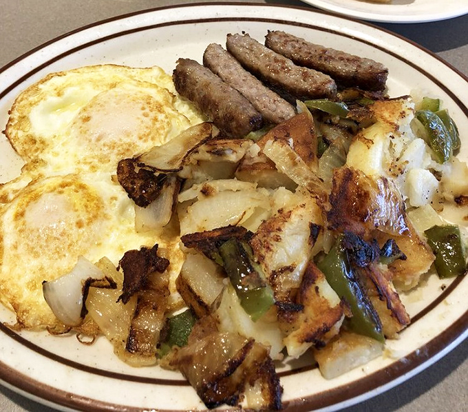 Breakfast alchemy at work: eggs, sausage, and potatoes with grilled peppers and onions. The kind of plate that makes you forget you own a kitchen.