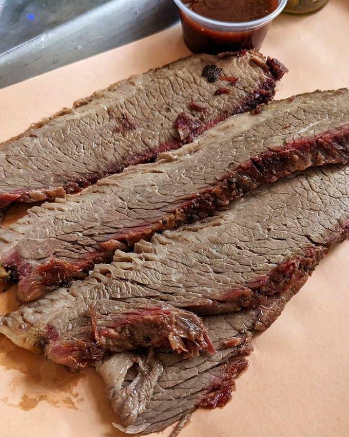 Brisket sliced thin enough to read through but thick with smoky flavor. That pink smoke ring is the BBQ equivalent of a Michelin star.