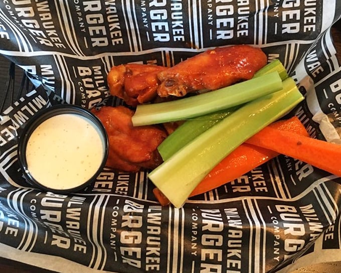 Buffalo wings served with the traditional celery stalks&mdash;nature's edible napkins. The sauce clings to each wing like it's afraid of missing the party.