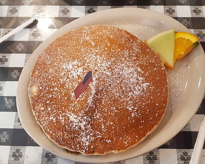 The pancake that launched a thousand return visits. Dusted with powdered sugar and sporting its own flag, it's breakfast patriotism at its most delicious.