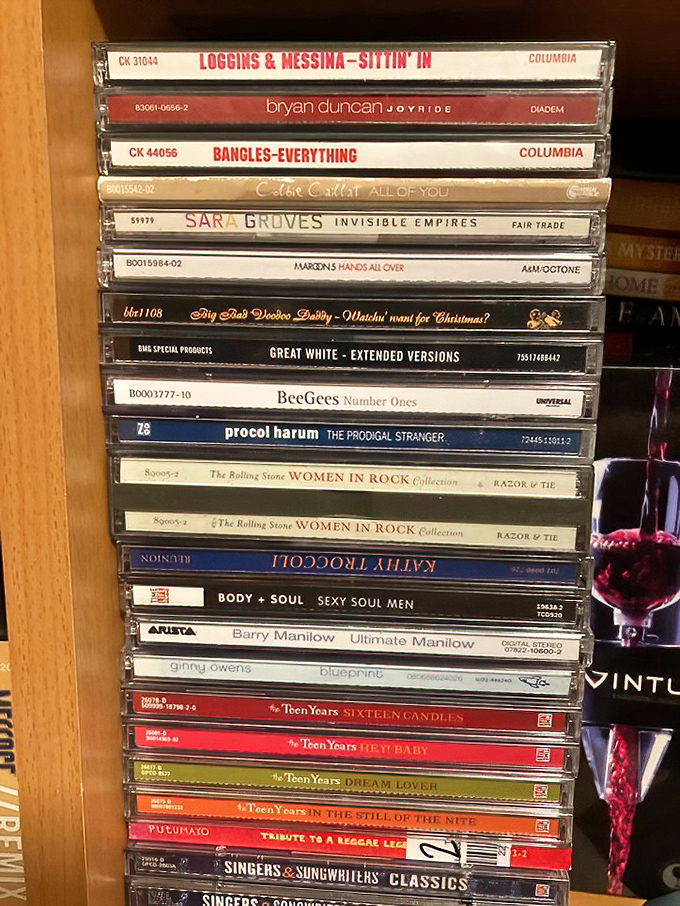 From Bangles to Barry Manilow, this CD collection spans decades of musical memories, each plastic case a time capsule of someone's soundtrack.