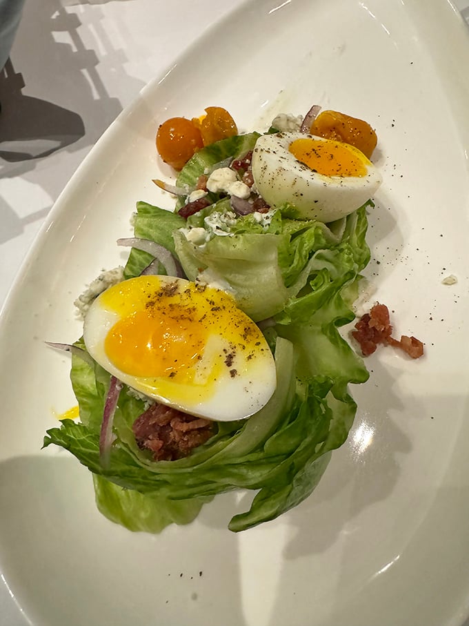 The humble wedge salad gets a gourmet makeover with perfectly soft-boiled eggs, creating a protein-packed prelude to the main event.