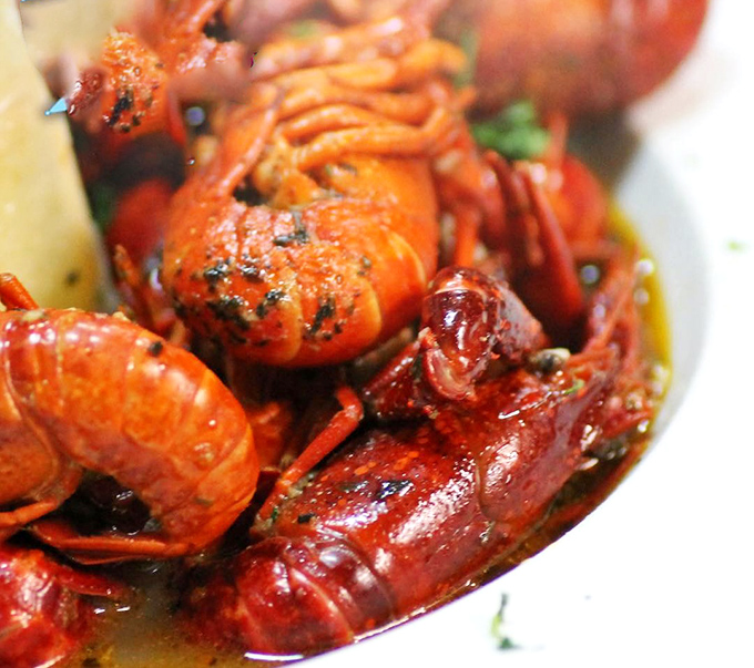 These crawfish look like they're having a spicy pool party. The kind of dish that justifies keeping an extra napkin tucked into your collar.