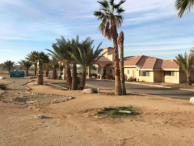 Palm trees frame the entrance to Calipatria Inn, offering desert travelers a respite where terra cotta roofs and stucco walls keep the fierce summer heat at bay.