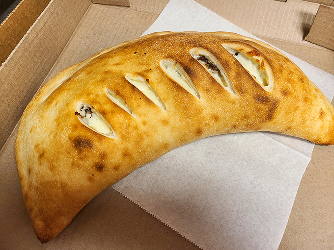 Behold the calzone in its natural habitat&mdash;a half-moon of doughy delight that's practically bursting with cheesy secrets.