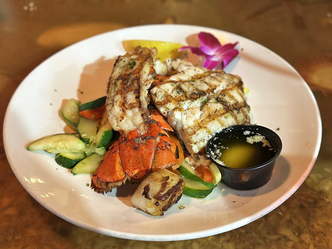 Grilled fish and lobster tail sharing a plate with fresh vegetables &ndash; proof that Florida seafood needs minimal intervention to shine.