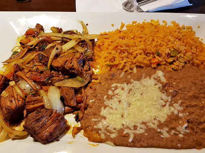 Tender carnitas with rice and beans create a plate that's both rustic and refined in presentation.