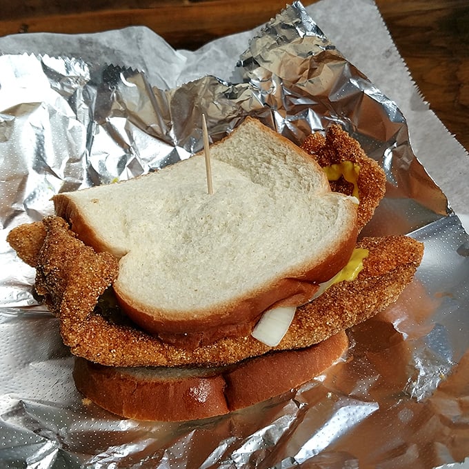 Architecture of flavor: layers of golden catfish peeking out between bread, with those signature rings of raw onion standing guard.