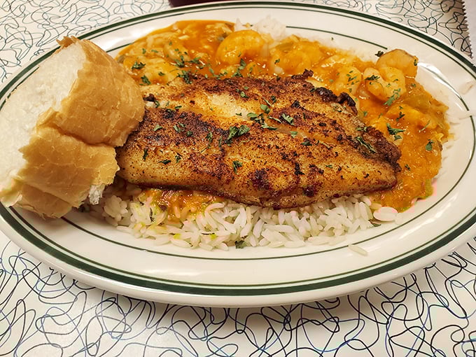 Blackened catfish resting on a bed of rice with a side of shrimp &eacute;touff&eacute;e &ndash; proof that Louisiana knows how to turn swimming creatures into edible poetry.